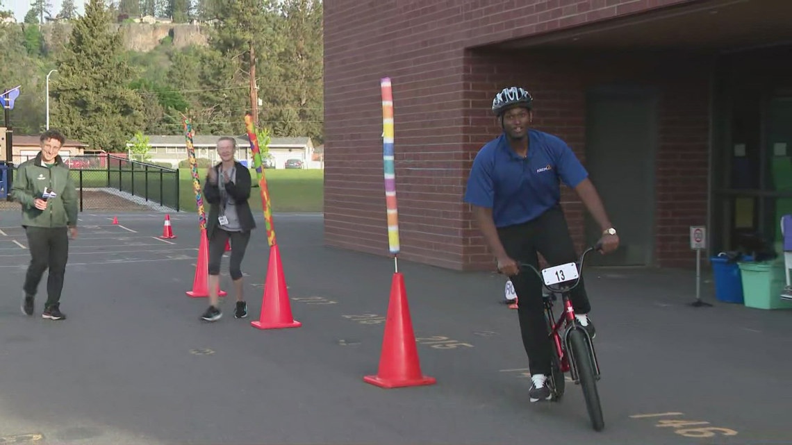 Linwood teachers show Brandon how to ride his bike through the learning course | krem.com